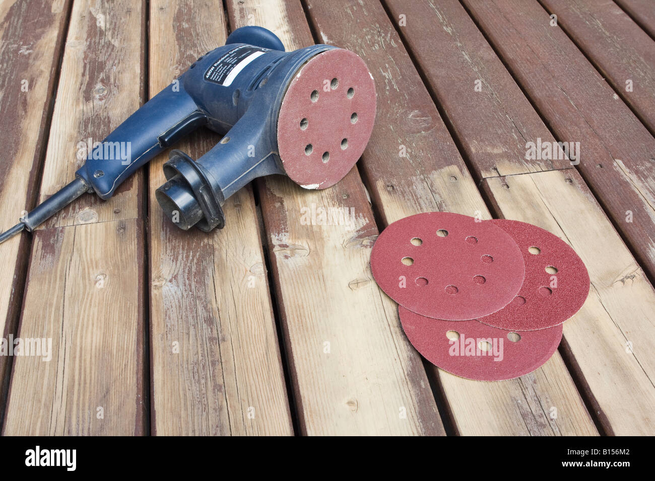 Random orbital sander lying on its side showing sanding disk and spares ...