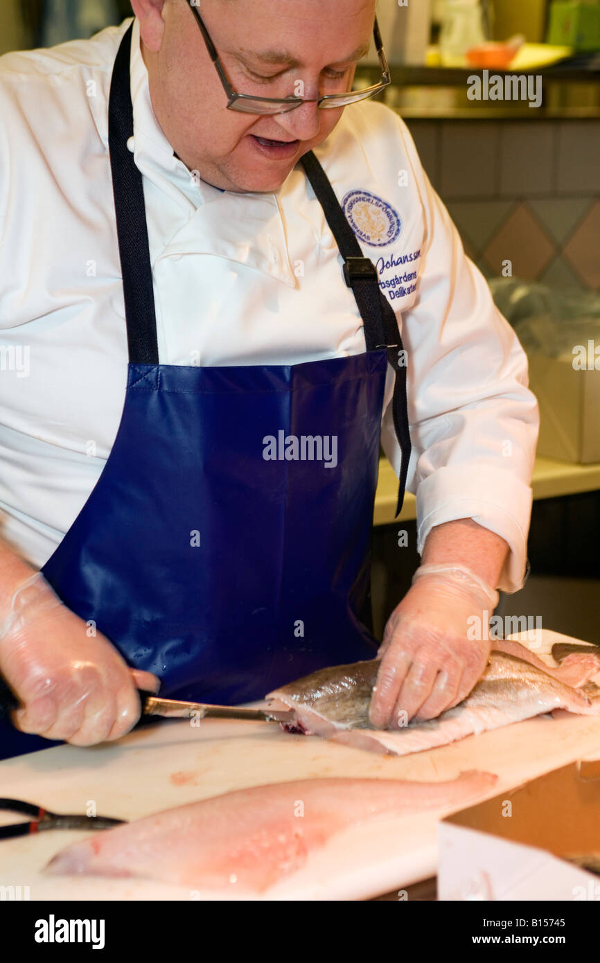 Chef and fishmonger Nils Johnson trims codfish filets during ...