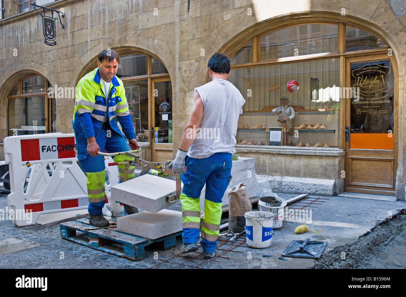 Construction workers carrying a slab of stone to be placed in a ...