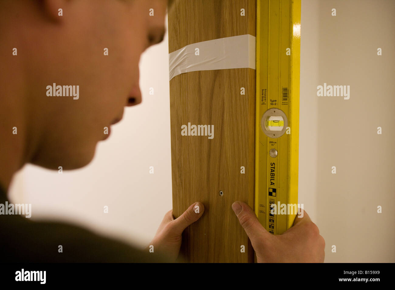 A workman checks a fitting with a spirit level Stock Photo - Alamy