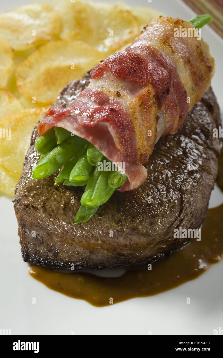 Sirloin steak with green beans wrapped in beacon and potatoes Stock ...