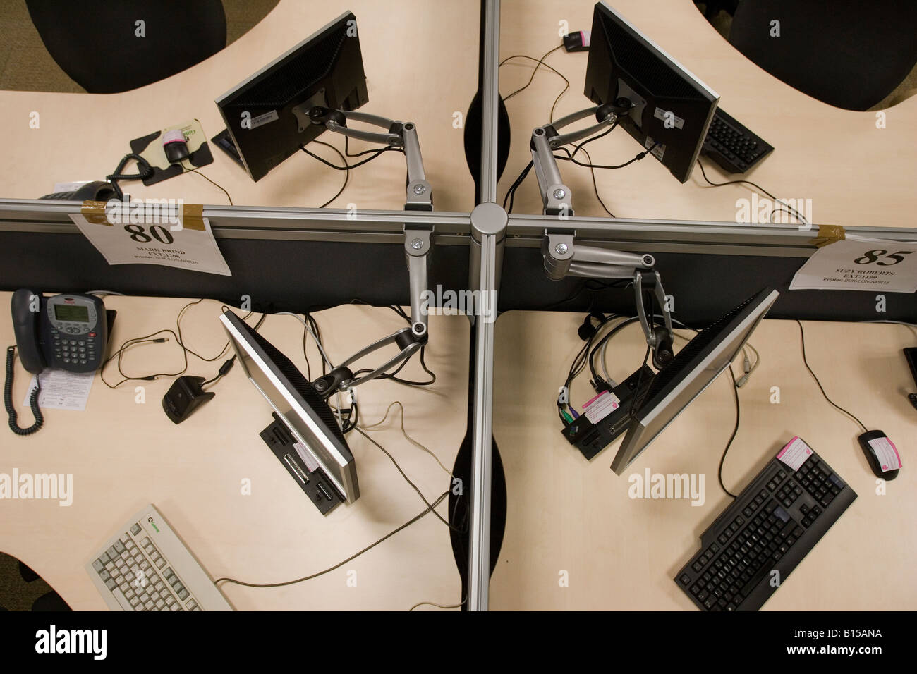 Four connected office desks, with swinging monitor arms, keyboards ...