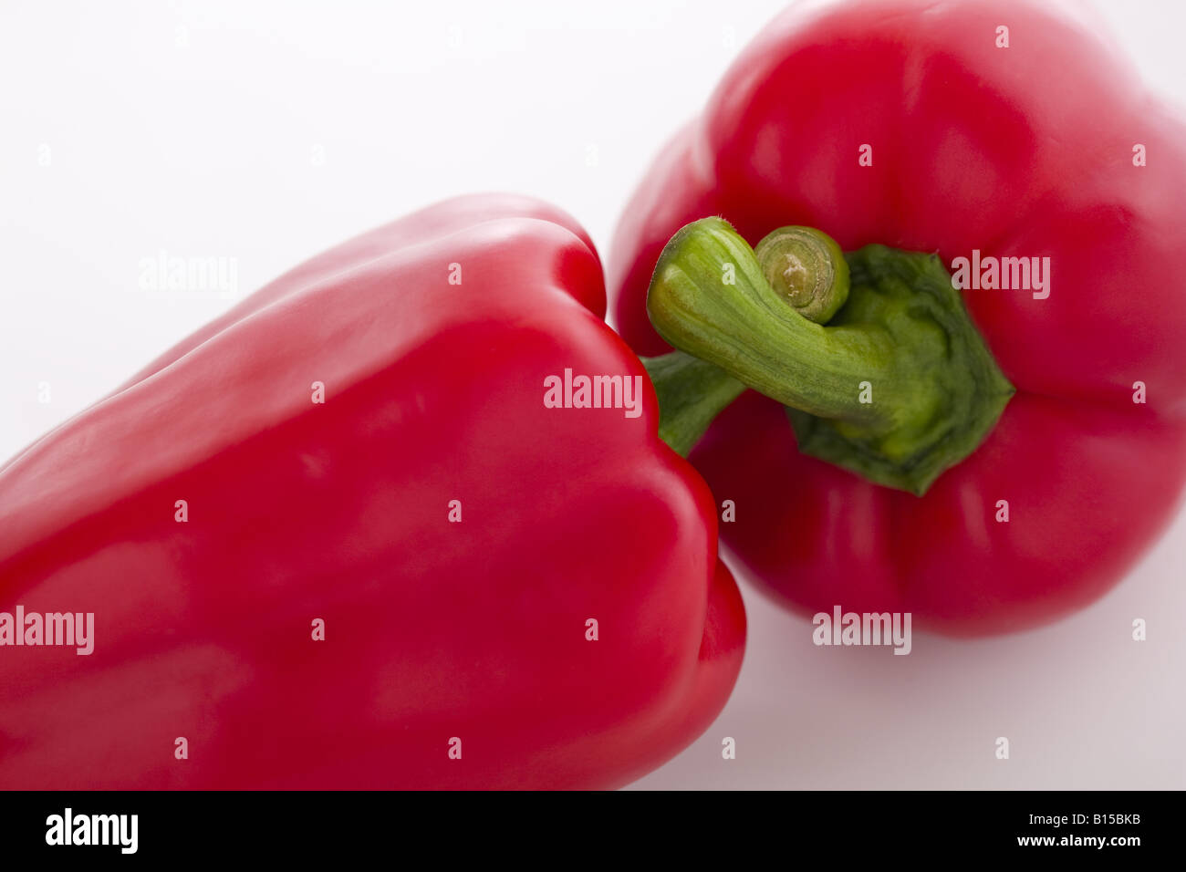 Close up of two red peppers against white background Stock Photo - Alamy