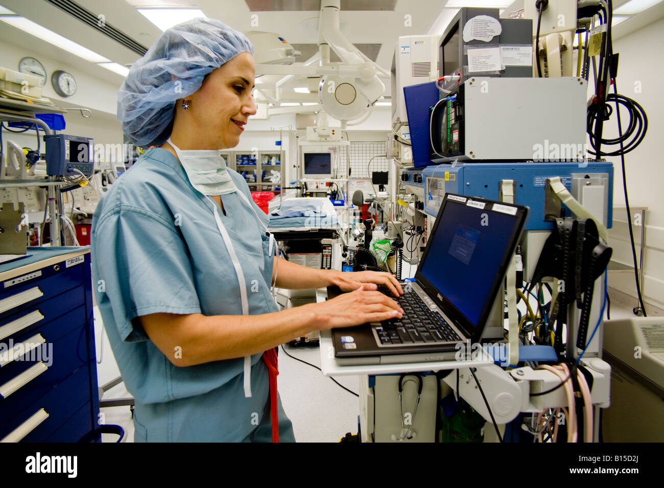 Prior to an operation a woman surgeon wearing scrubs enters pertinent ...