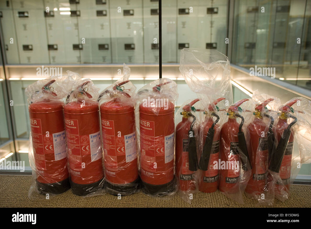 New fire extinguishers sit, covered in cellophane wrapping, waiting to ...