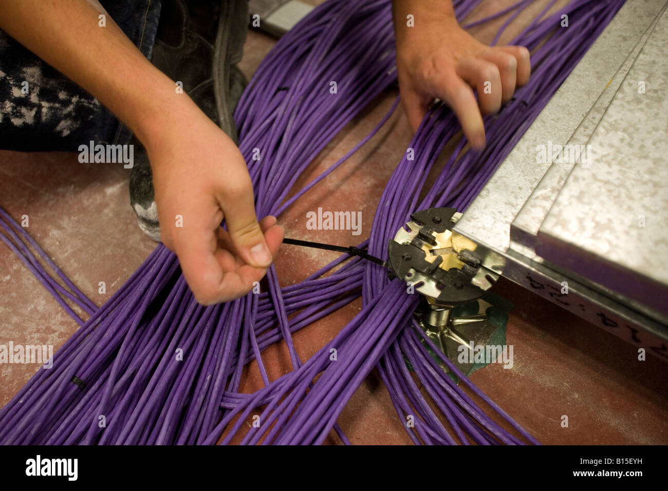 An engineer installs underfloor data cables in a newly constructed ...