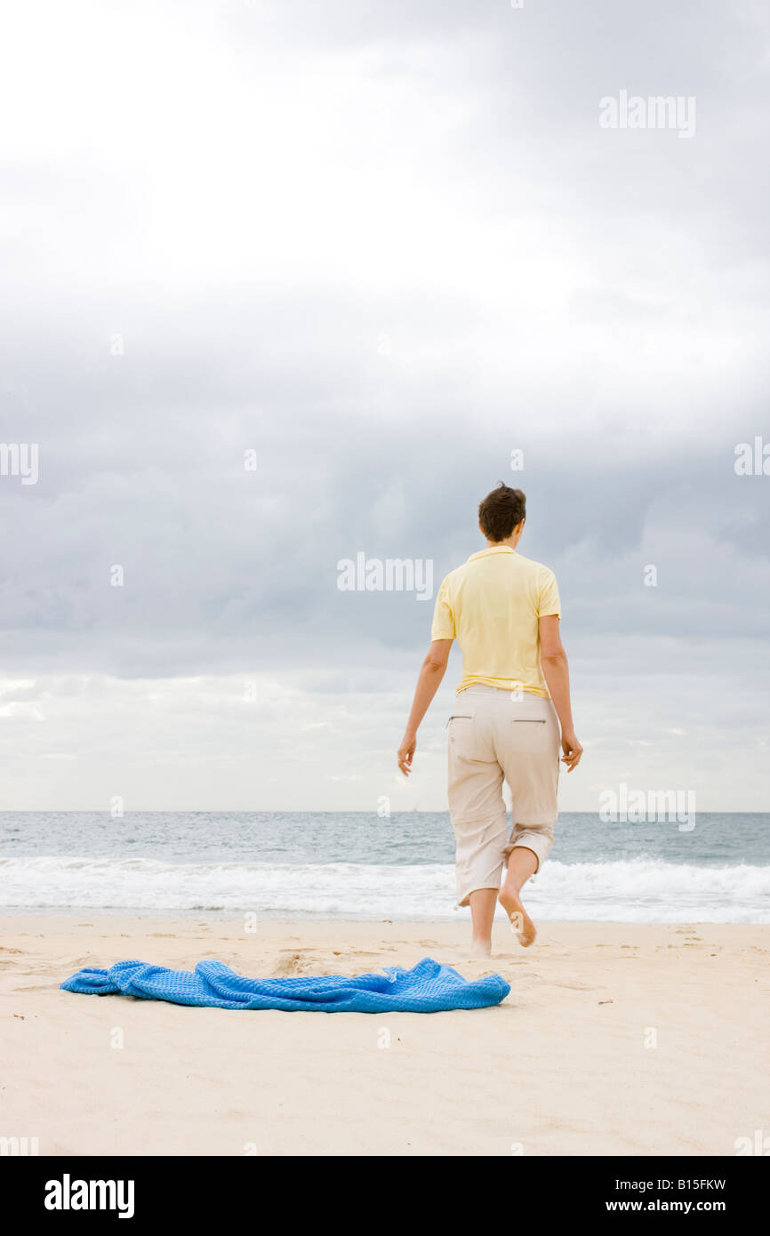 Woman walking on a beach Focus on the towel in the foreground Stock ...