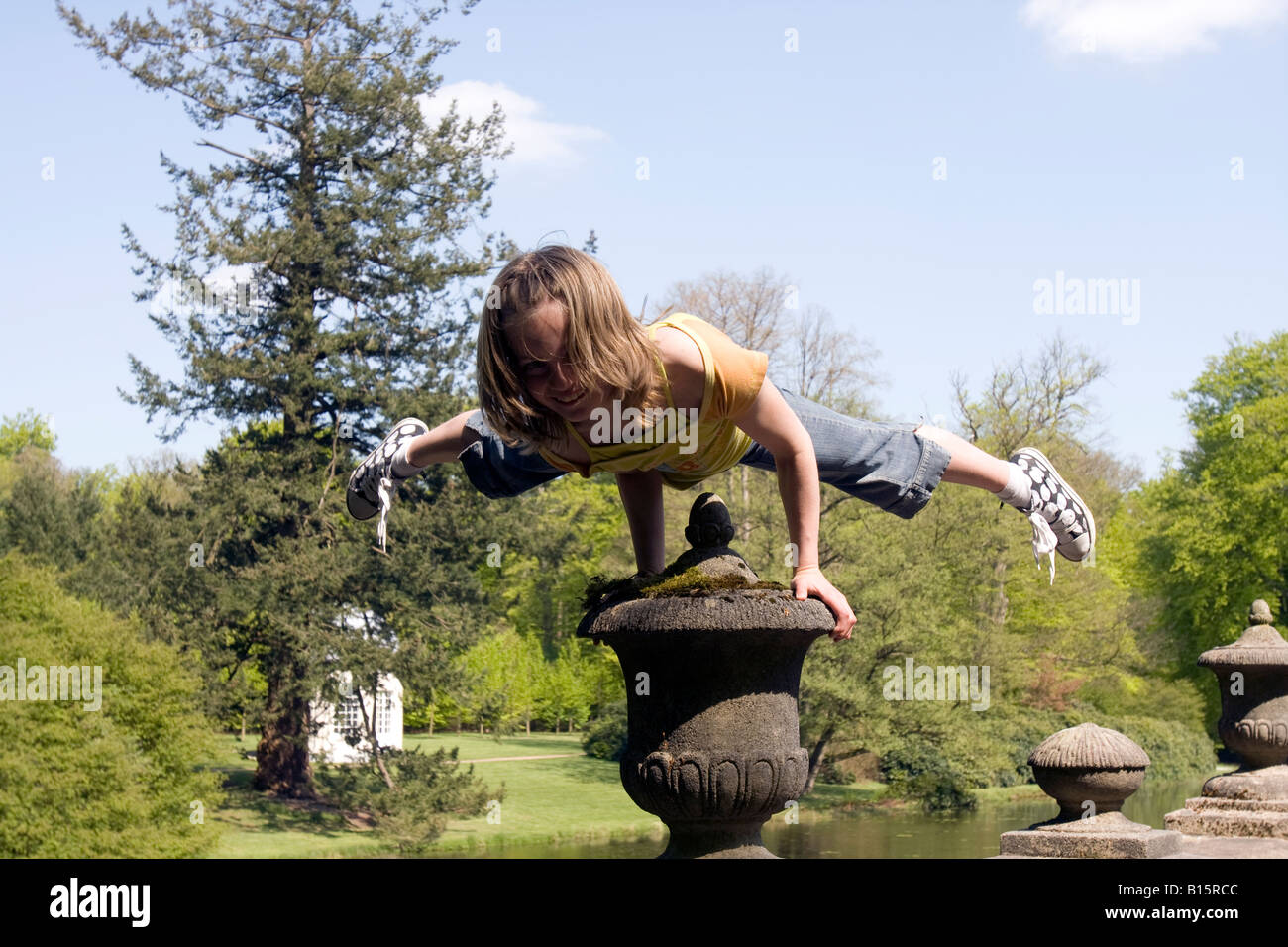 Eight year old blond girl performing acrobatic gymnastics on a vase in ...