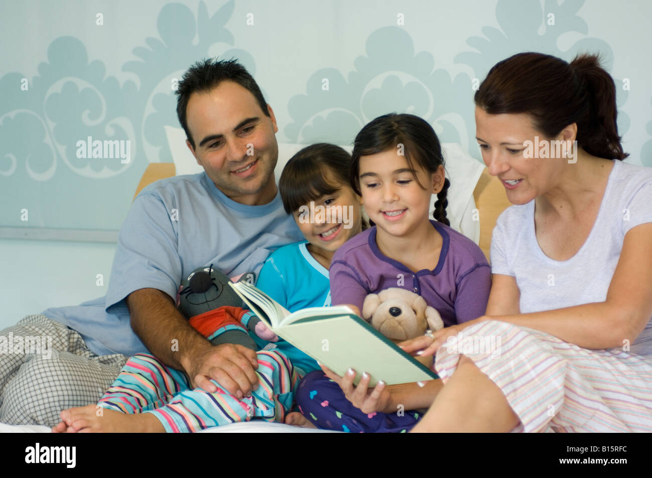 Family reading together in bedroom Stock Photo - Alamy
