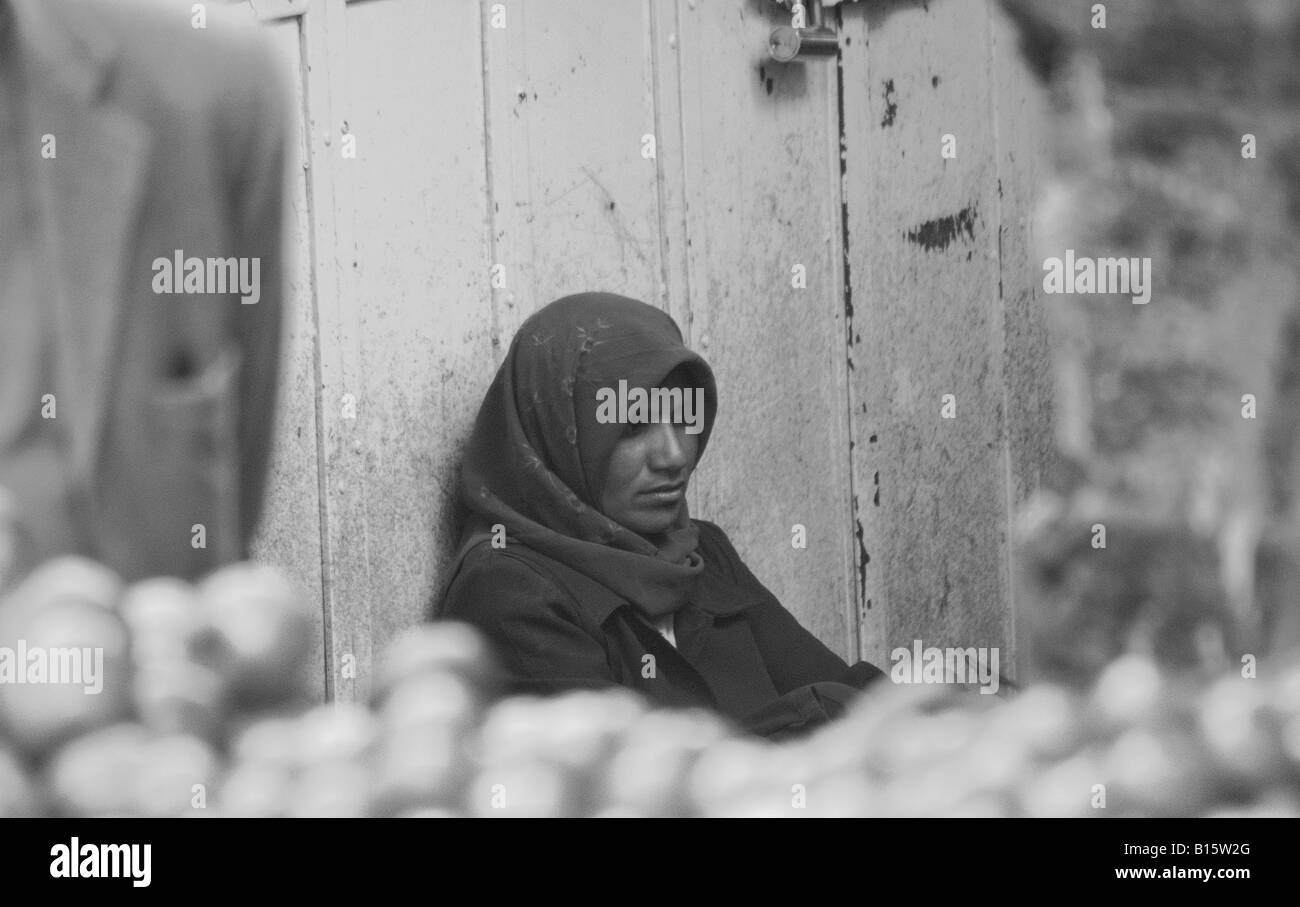 A woman sits alone, in silence, on the ground at the bustling Arab ...