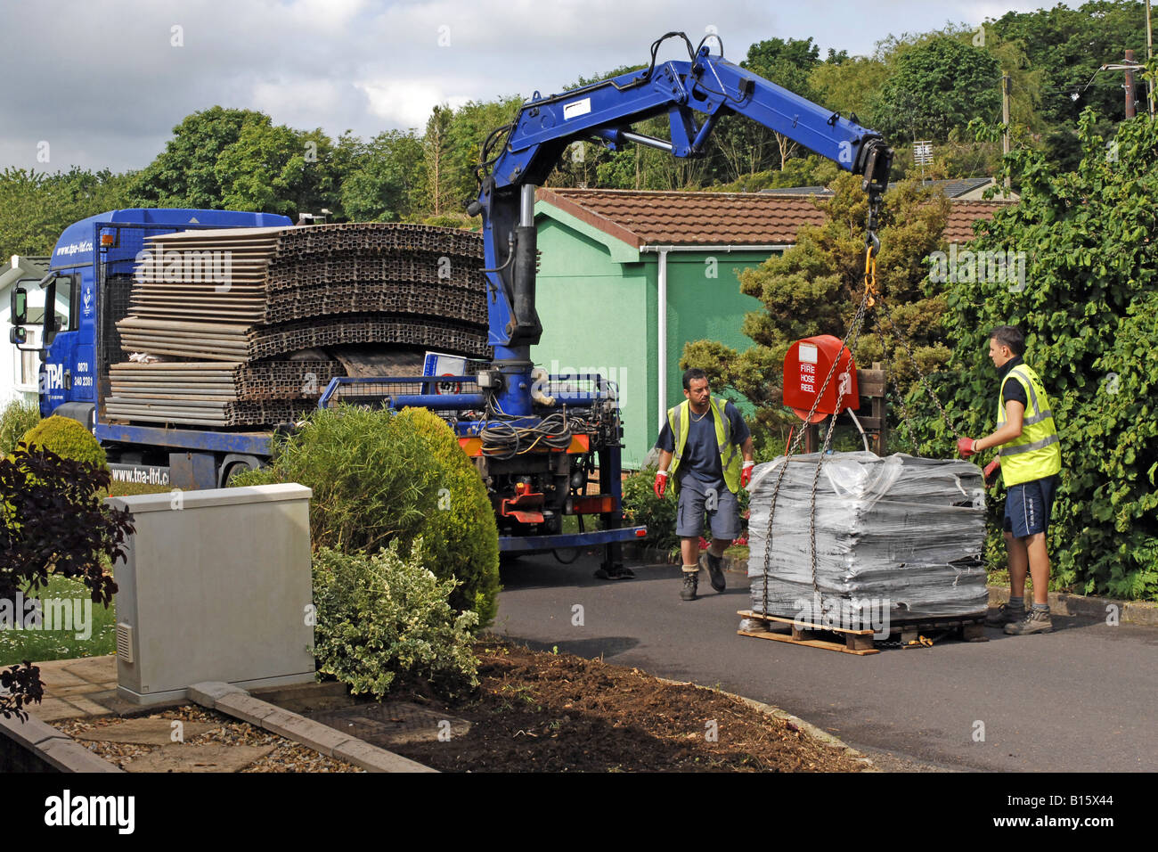 Men laying an aluminum road track on soft ground Stock Photo - Alamy