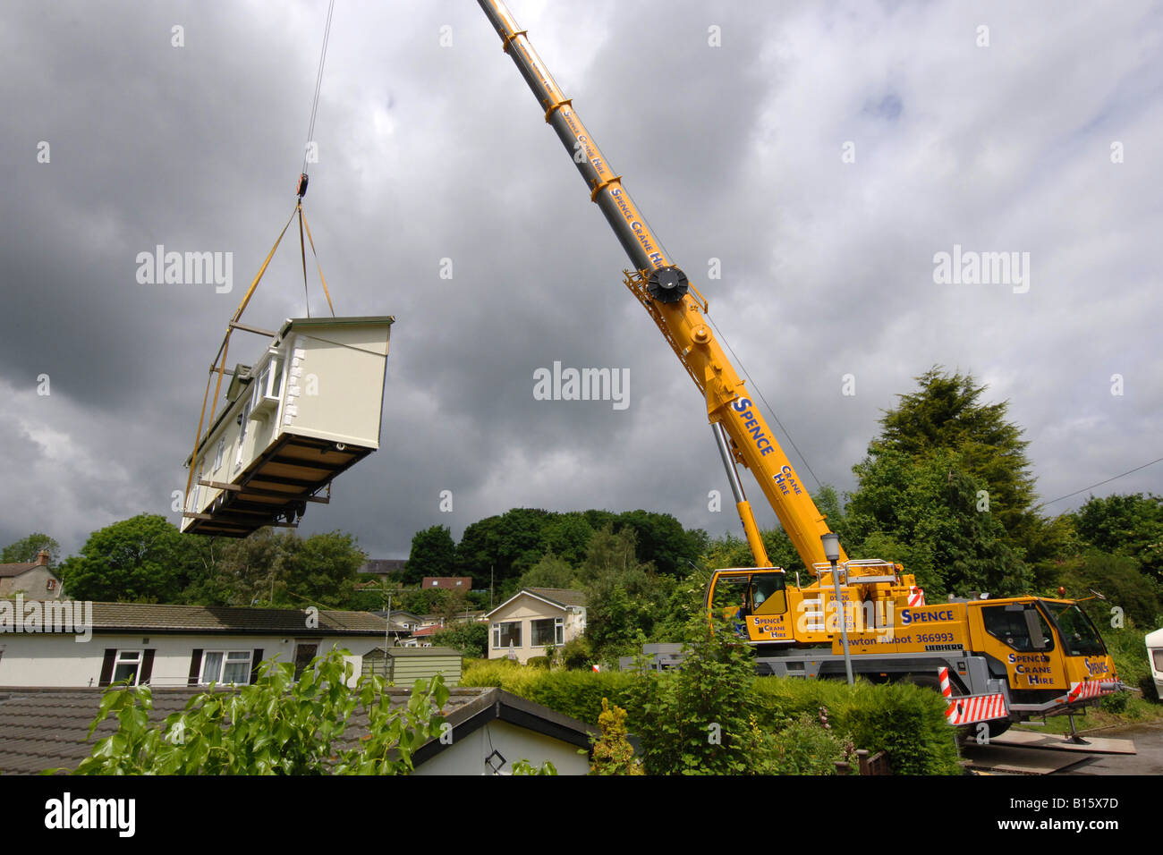 Half of a mobile home being lifted onto it s site by a giant crane ...