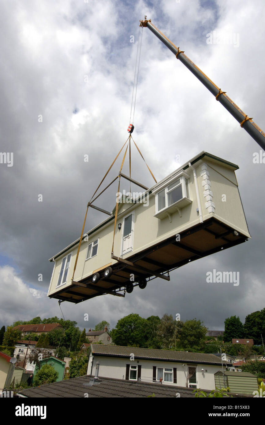 Half of a mobile home being lifted onto it s site by a giant crane ...