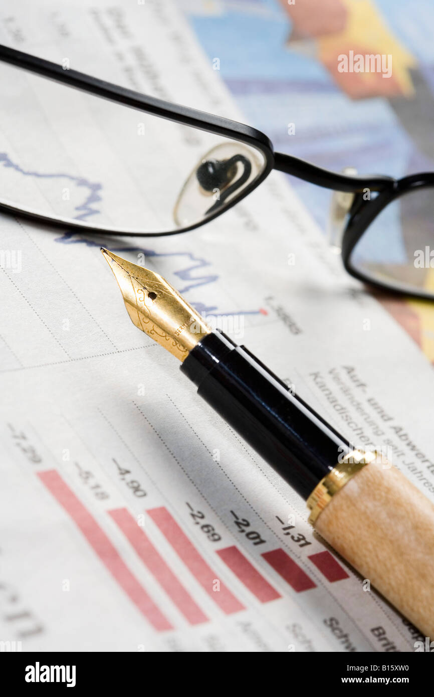 Pen and spectacles on newspaper, close-up Stock Photo - Alamy