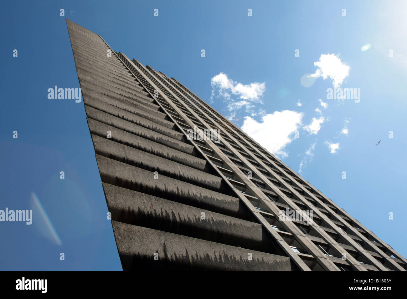 Cromwell Tower, The Barbican, London, with a commercial jet flying ...