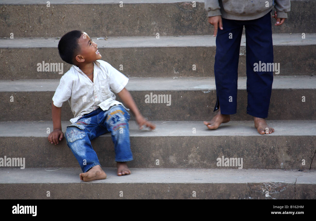 Laos Children waiting on steps Stock Photo - Alamy