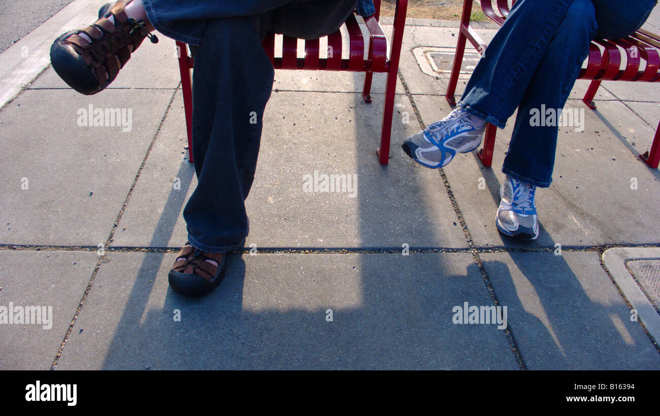 Two people waiting at the bus stop, early morning Stock Photo - Alamy