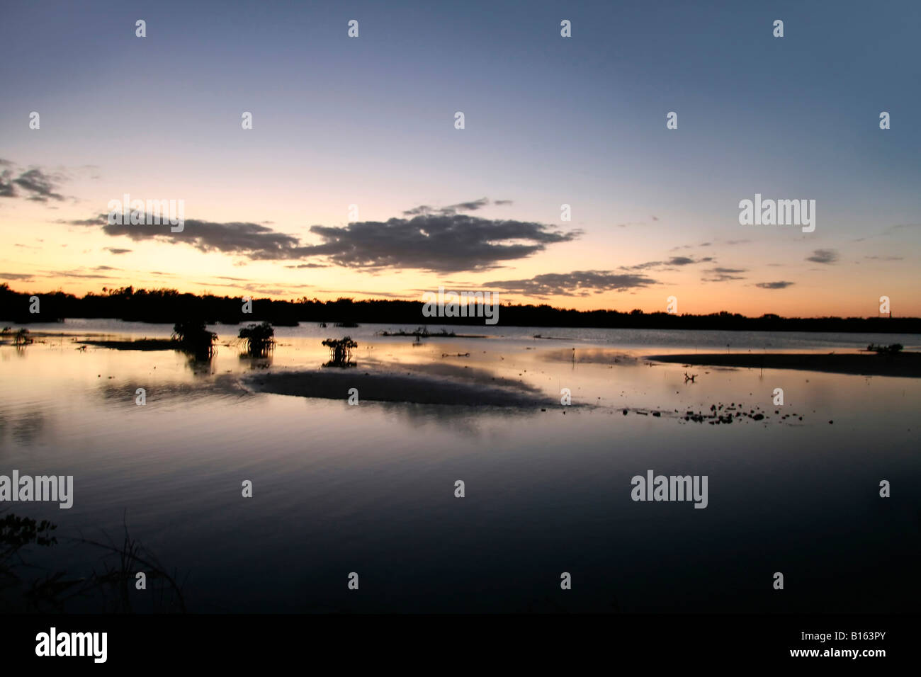 Sunset reflection red sky clouds water calm Stock Photo - Alamy