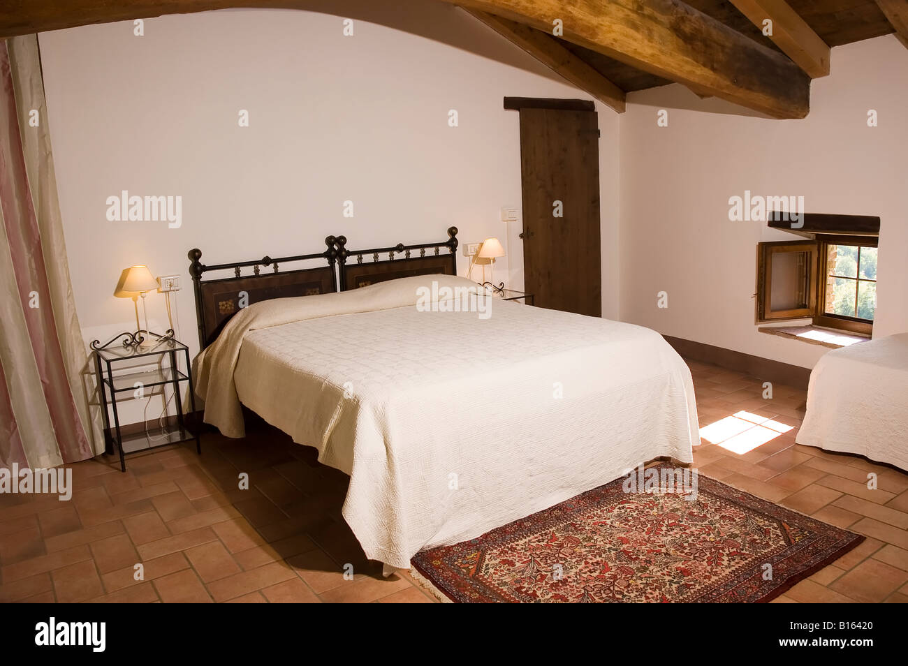 Double bed in a rustic hotel room with wooden beams in the ceiling ...