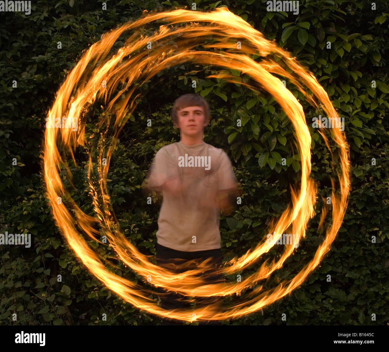 Teenage boy playing with fire staff Stock Photo - Alamy