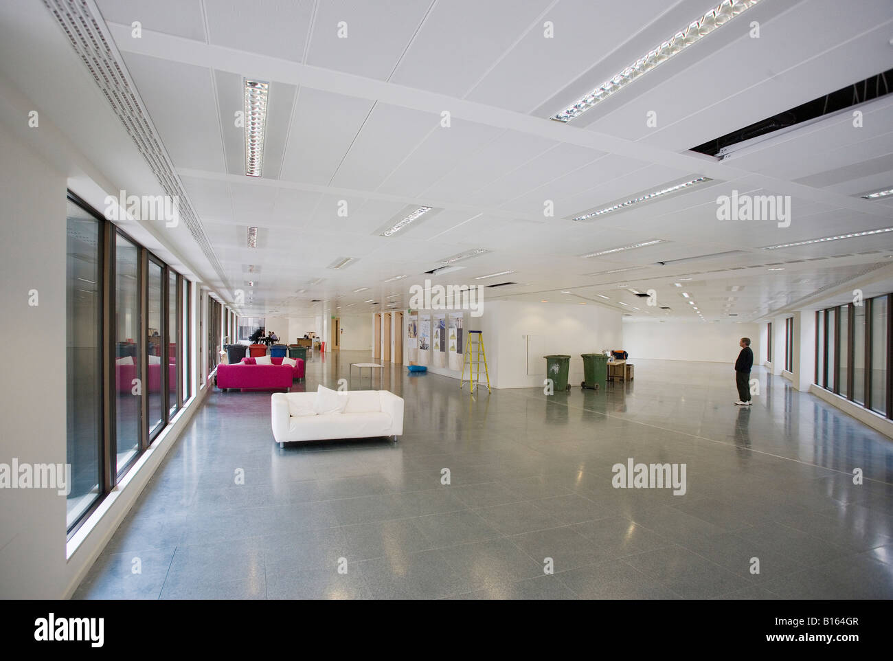 Sofas sit in the middle of the room in a newly built office building ...