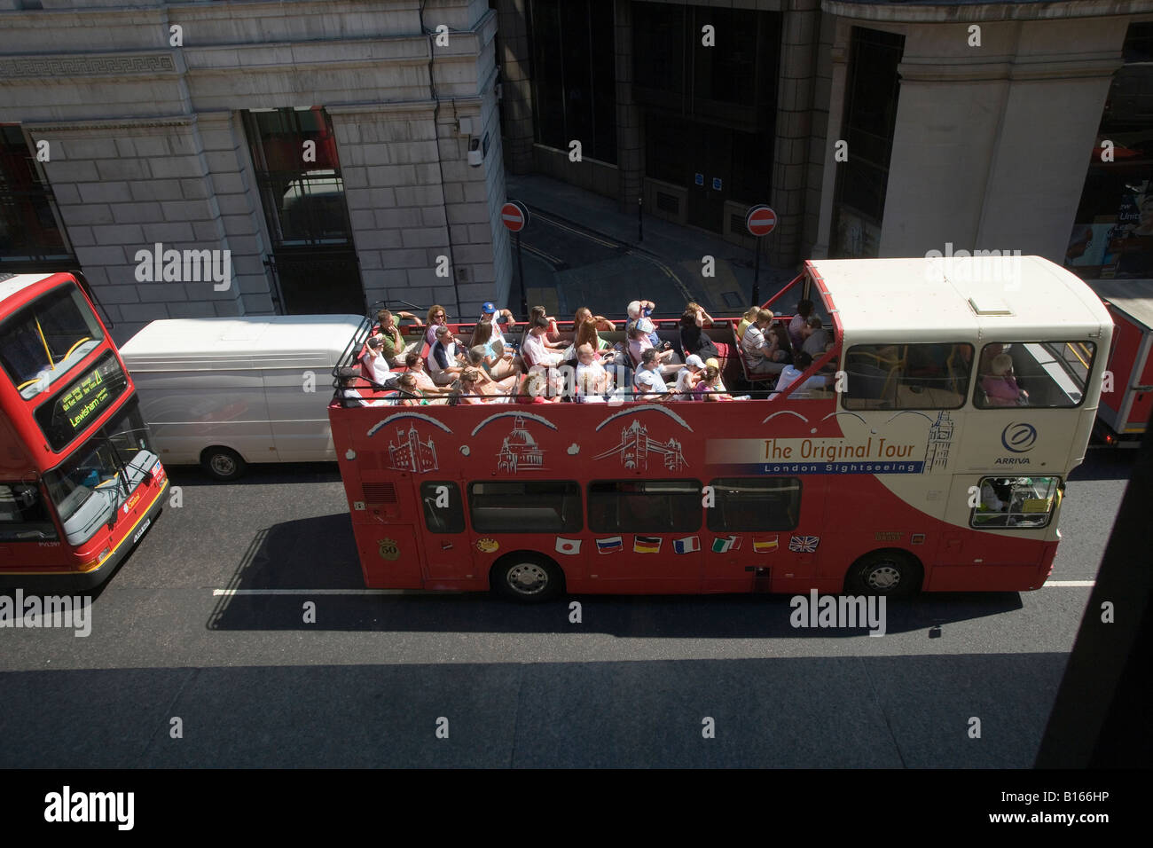 An open-topped bus full of tourists passes by a newly built office ...