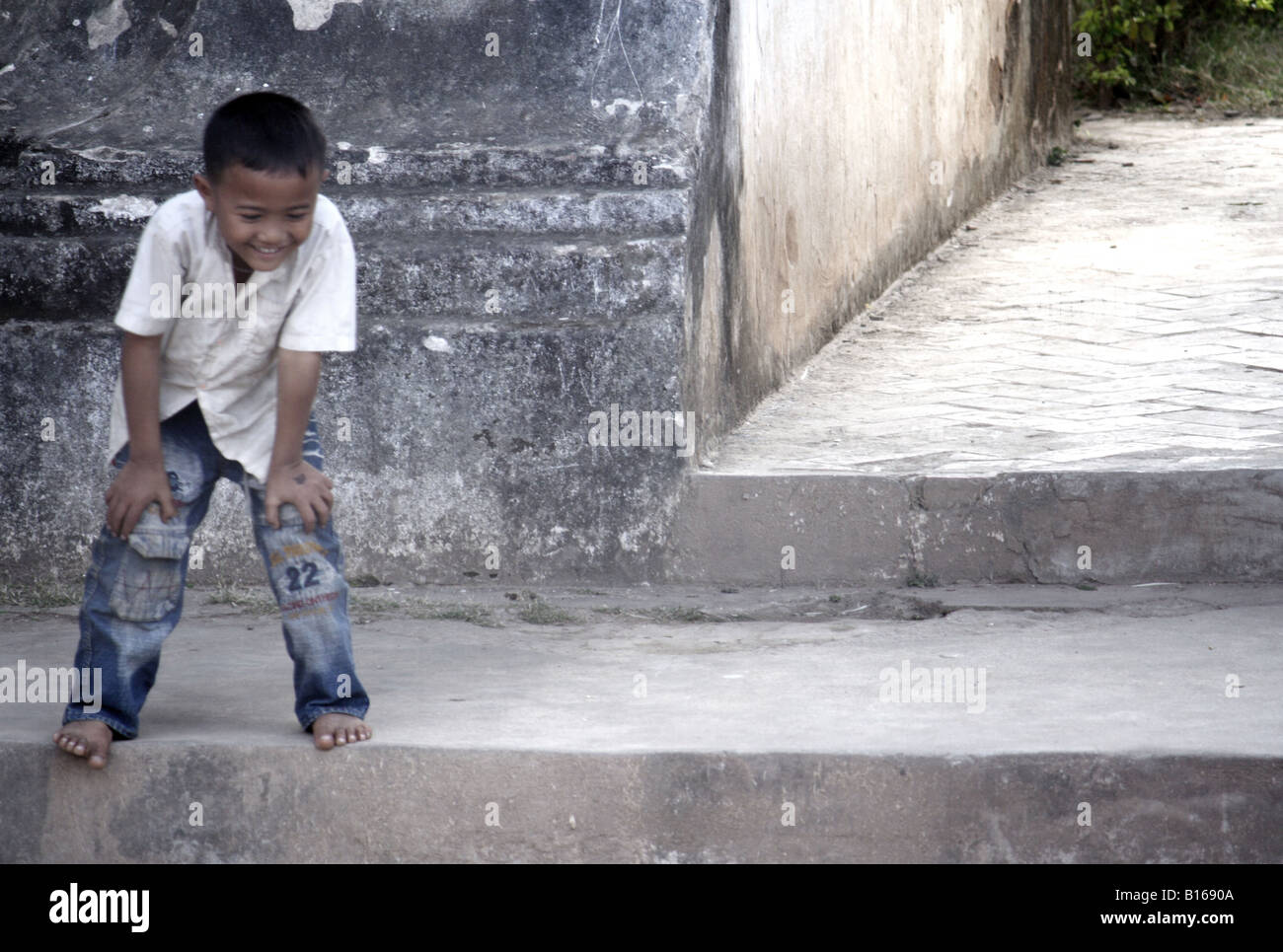 Laos Child waiting on steps Stock Photo - Alamy