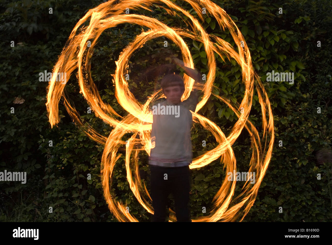 Teenage boy playing with fire staff Stock Photo - Alamy