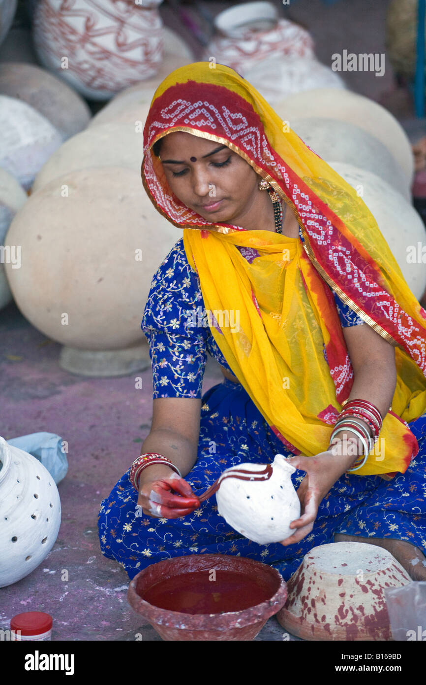 A Rajasthani woman paints a clay pot for the GANGUR FESTIVAL in JOHDPUR ...