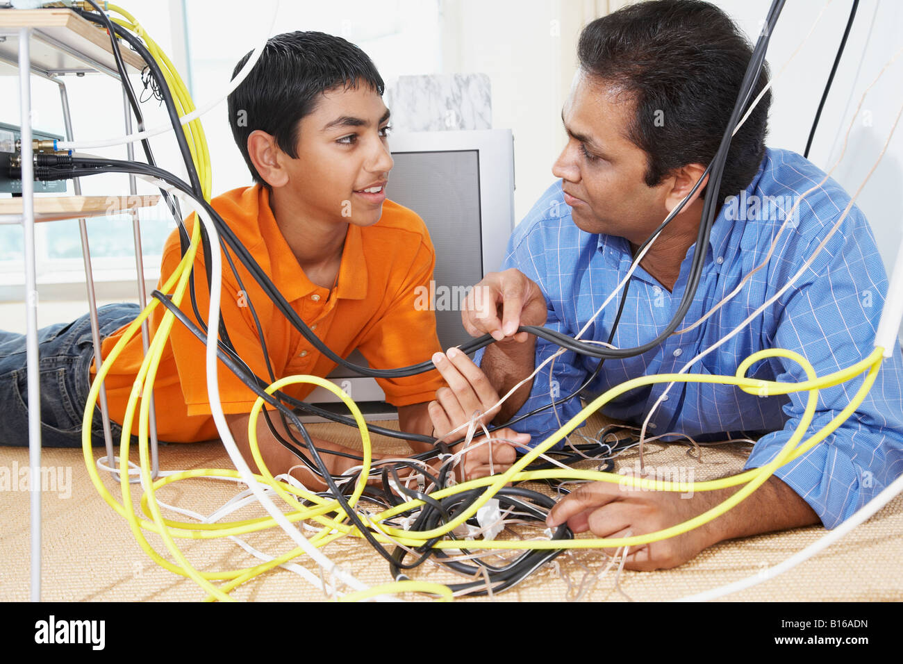 Middle Eastern father and son untangling wires Stock Photo - Alamy