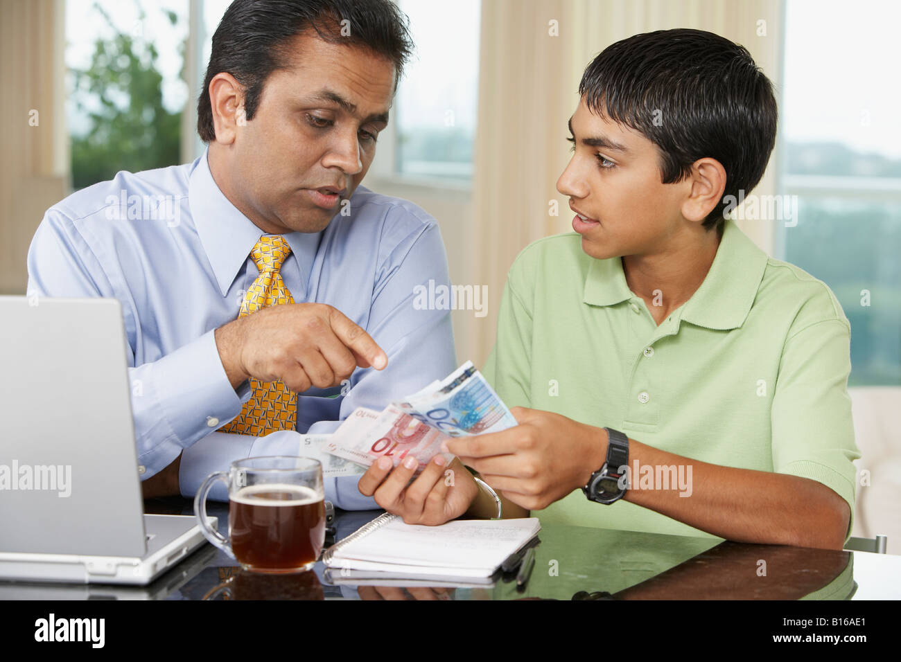 Middle Eastern father and son counting money Stock Photo - Alamy