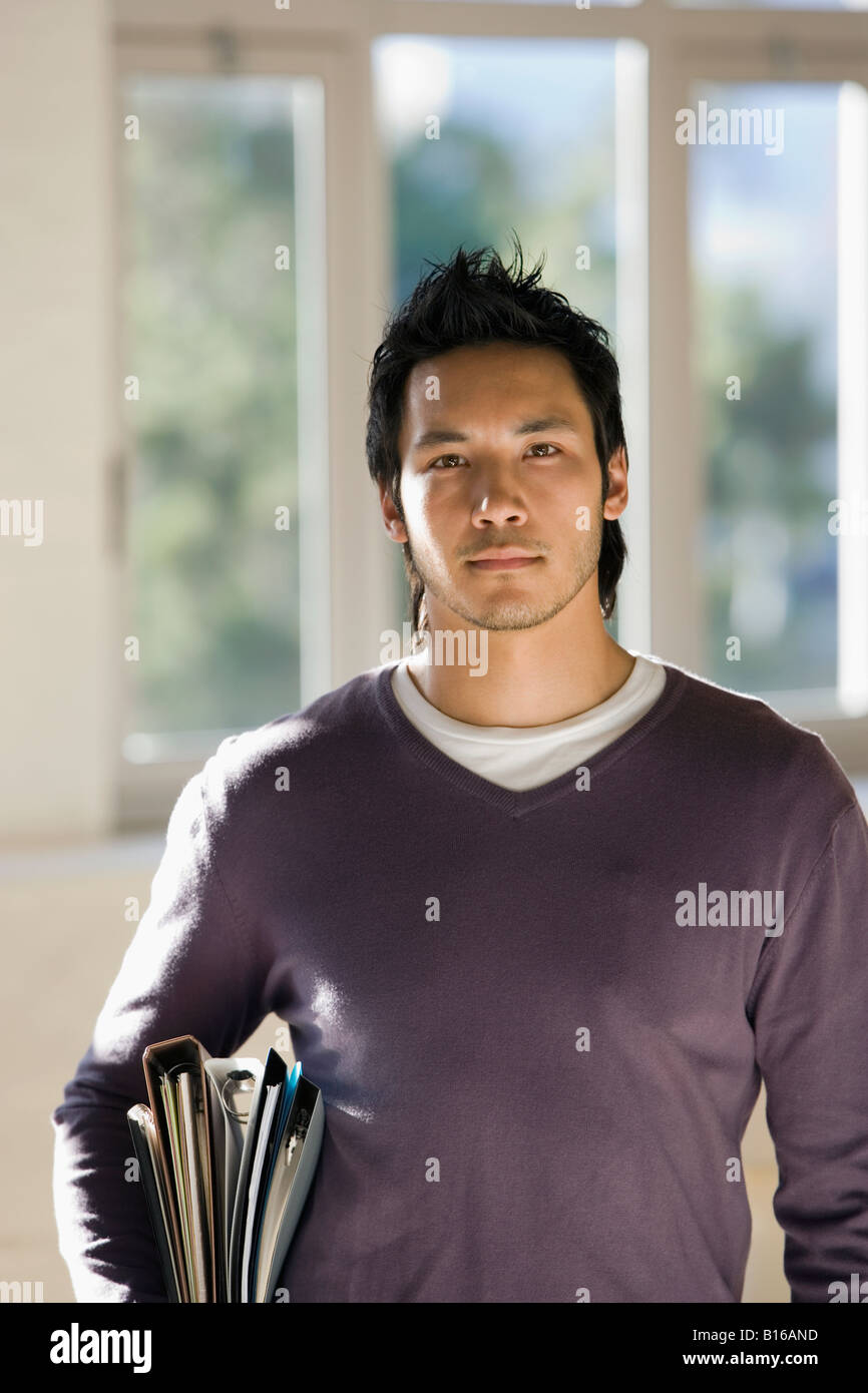 Asian man carrying binders Stock Photo - Alamy
