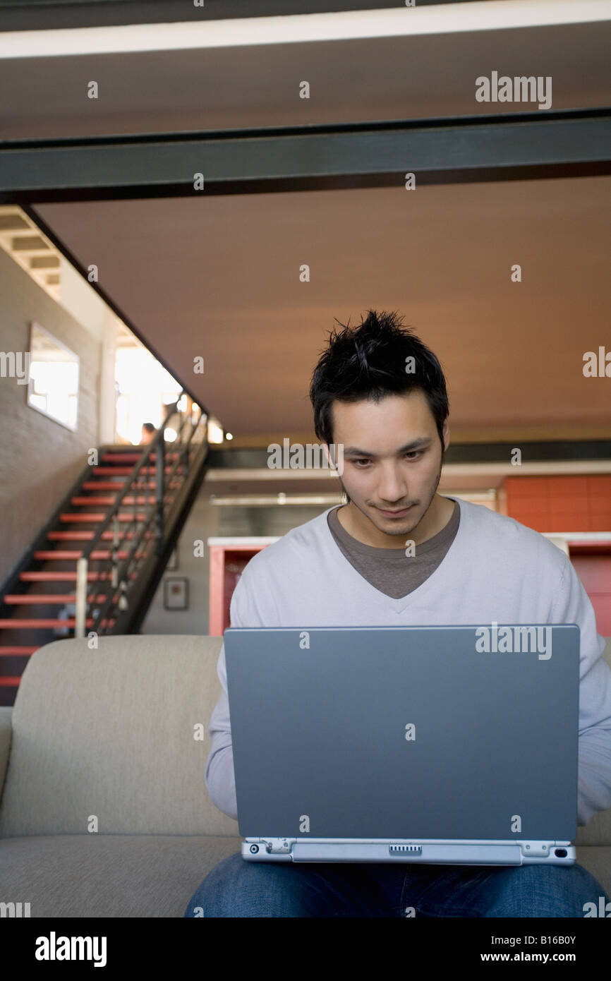 Asian man looking at laptop Stock Photo - Alamy