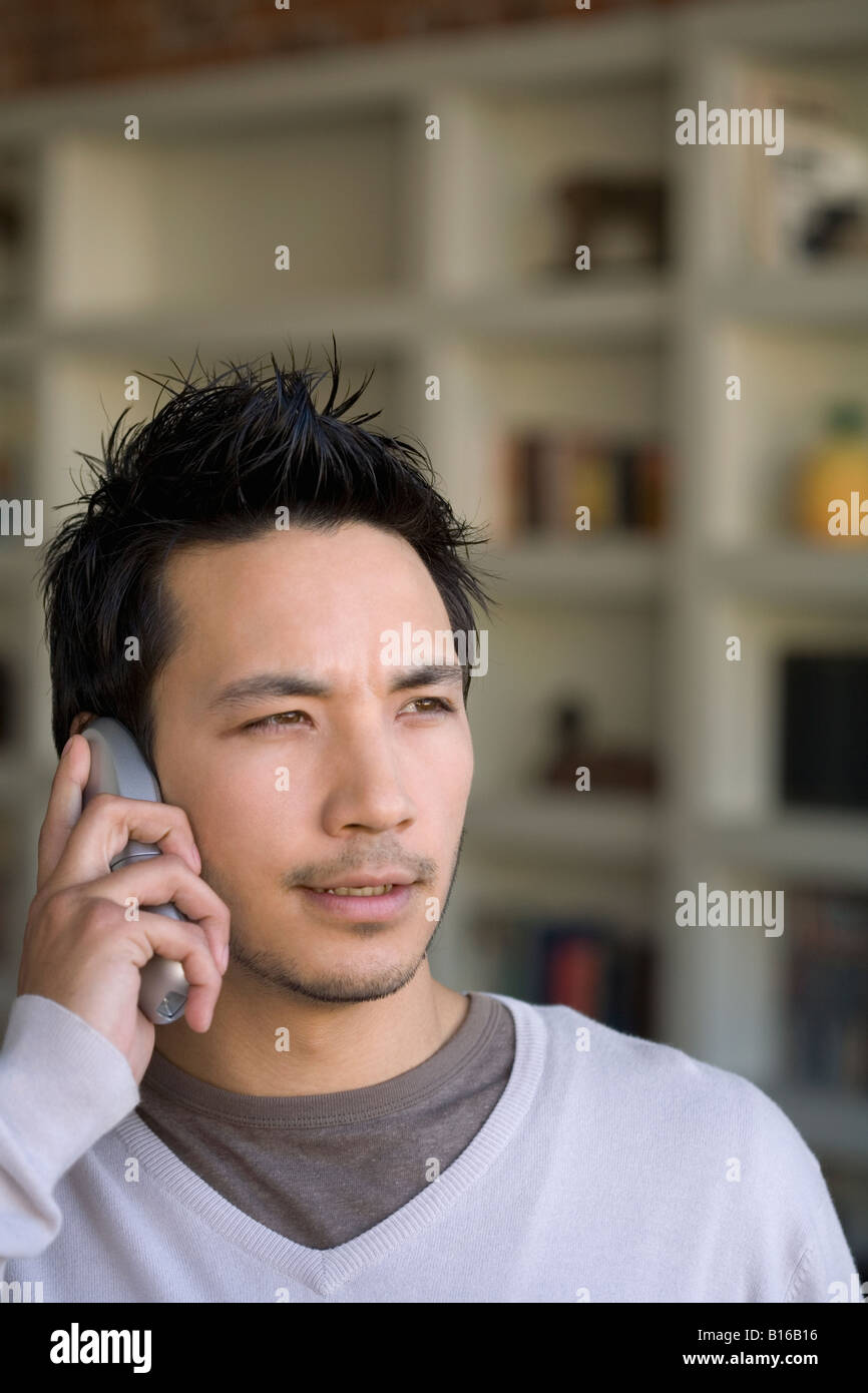 Asian man talking on telephone Stock Photo - Alamy