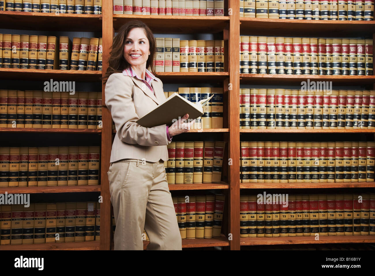 Hispanic woman reading library reference book Stock Photo - Alamy