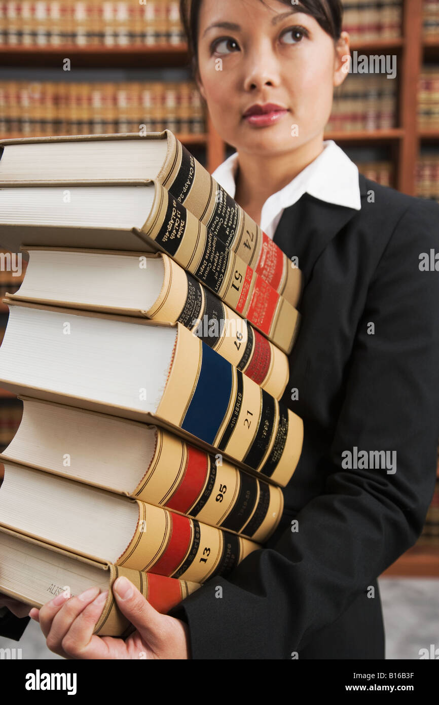 Asian woman carrying stack of library reference books Stock Photo - Alamy