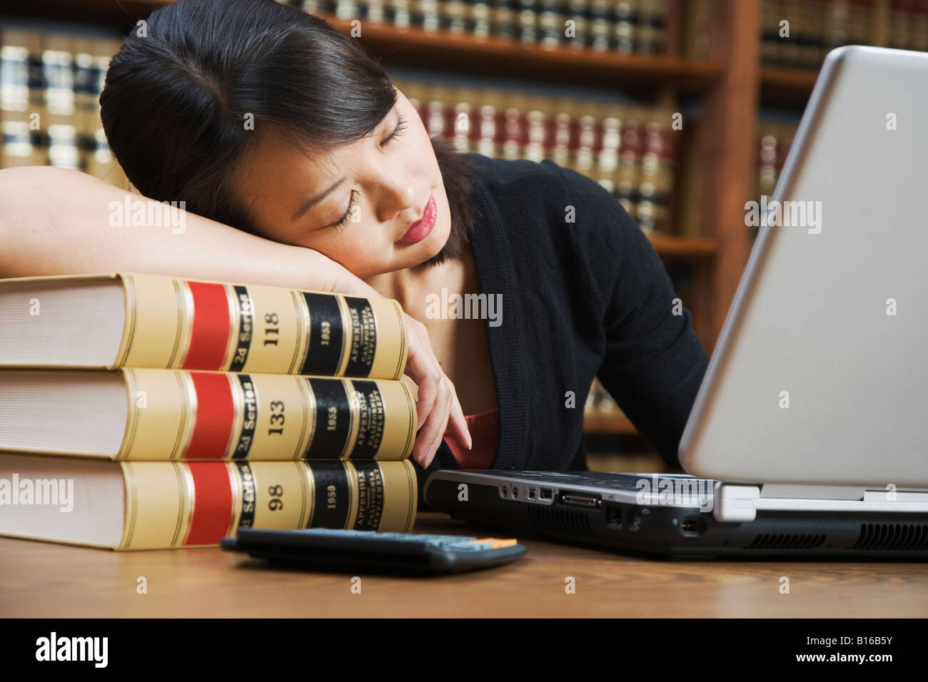Asian woman sleeping on stack of library books Stock Photo - Alamy