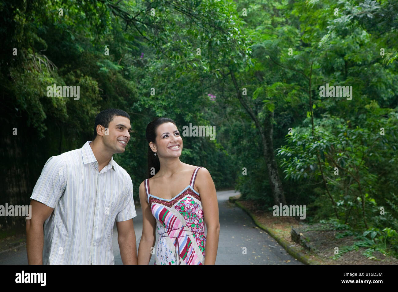 Hispanic couple on road in woods Stock Photo - Alamy