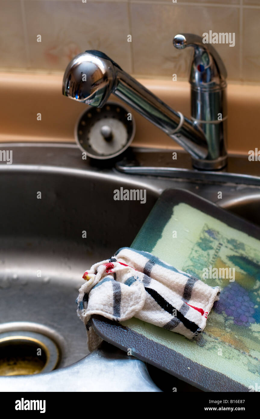 A washing rag sits ontop of a washed cutting board in a sink Stock ...