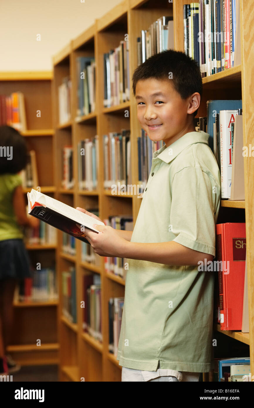 Asian boy holding library book Stock Photo - Alamy