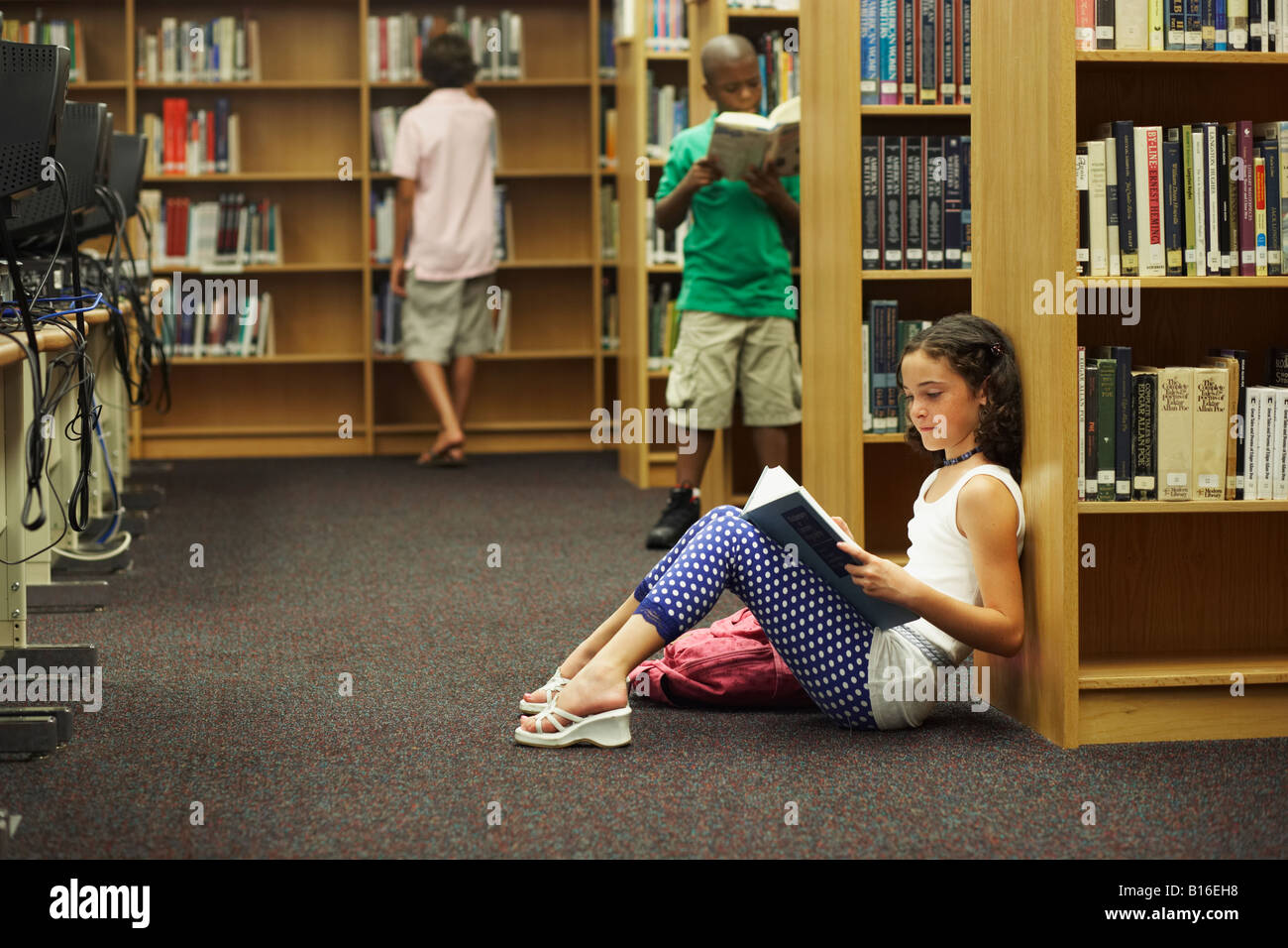 Multi-ethnic students reading library books Stock Photo - Alamy