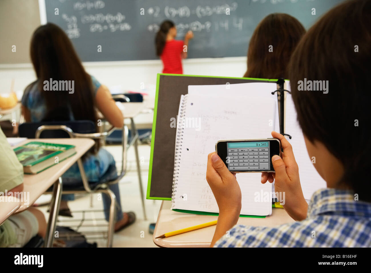 Asian boy using calculator in class Stock Photo - Alamy