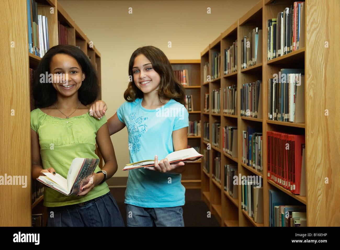 Multi-ethnic girls holding library books Stock Photo - Alamy