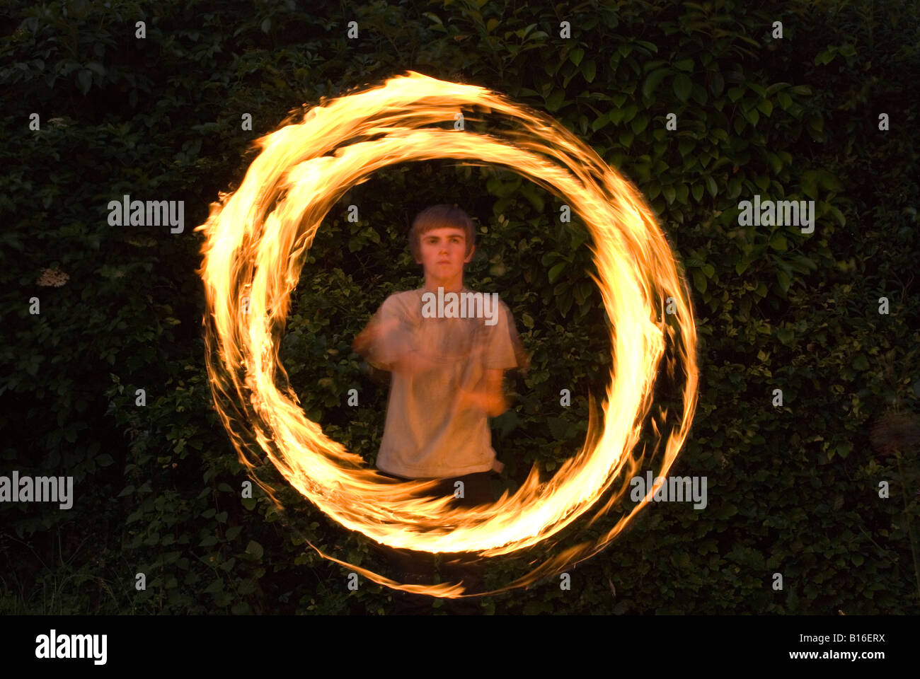 Teenage boy playing with fire staff Stock Photo - Alamy
