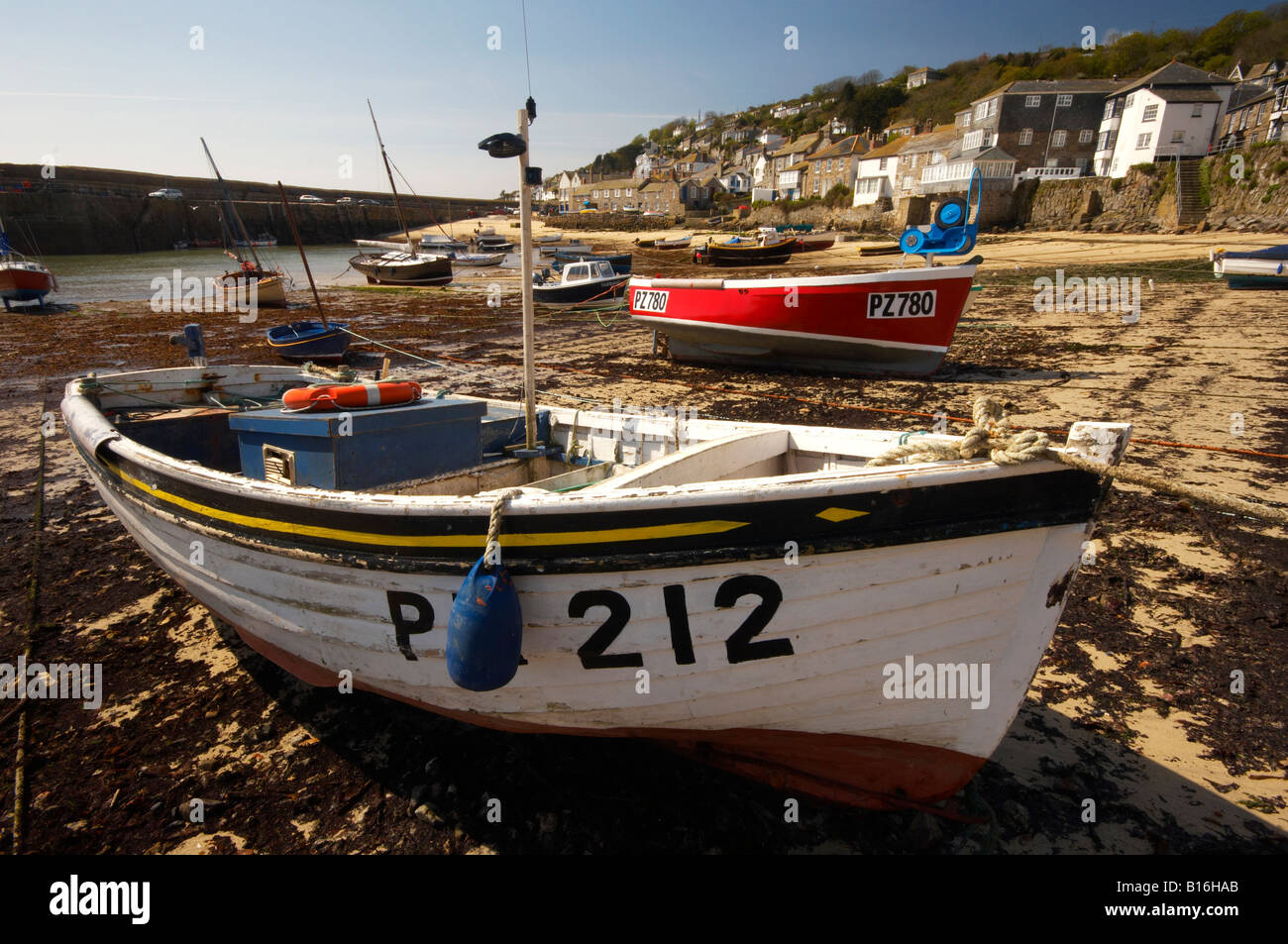 Fishing boats at low tide in Mousehole harbour Cornwall UK Stock Photo ...