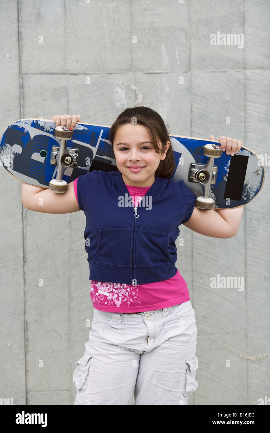Mixed Race girl holding skateboard Stock Photo - Alamy