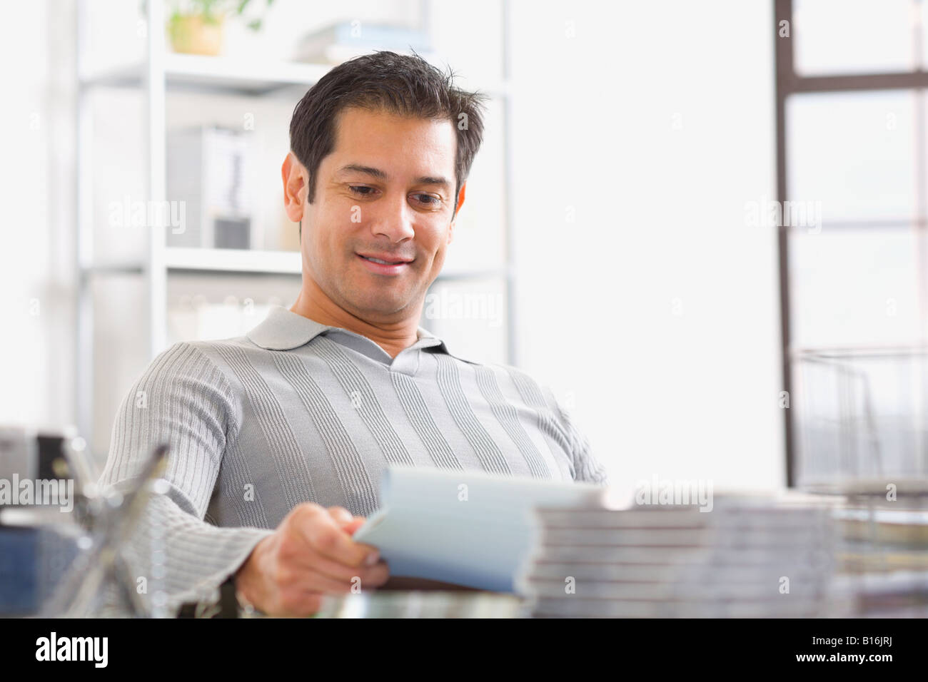 Hispanic man reading paperwork Stock Photo - Alamy