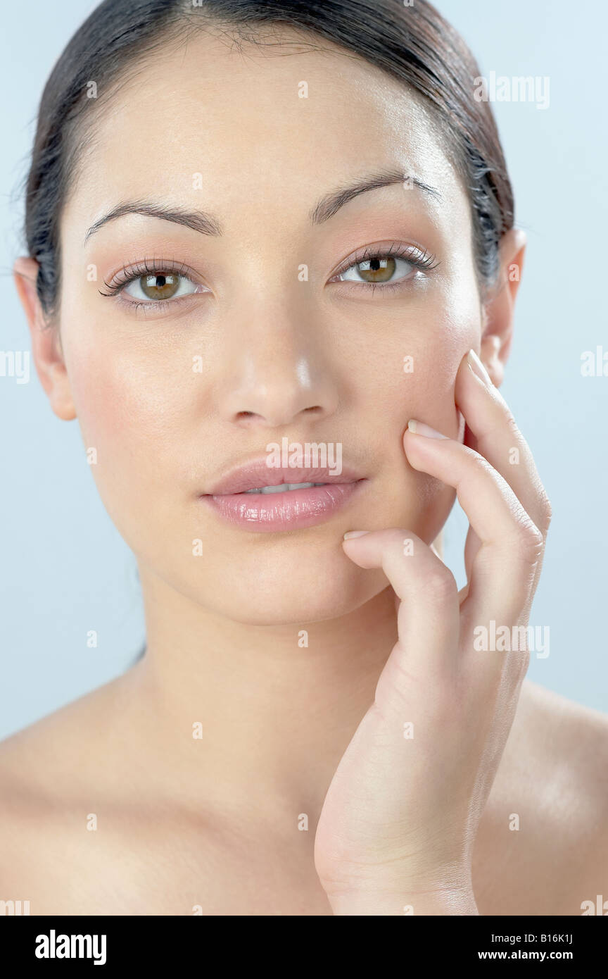 Mixed Race woman with hand on face Stock Photo - Alamy