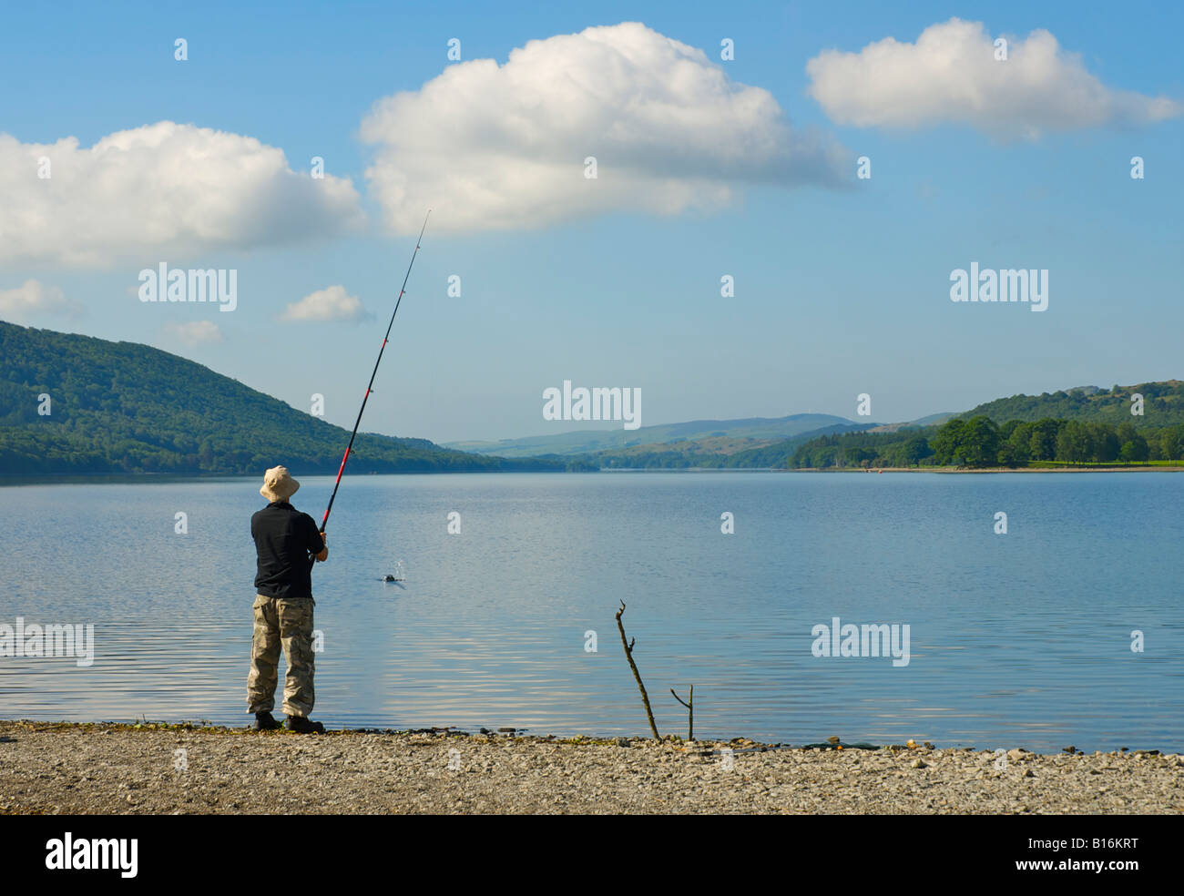 Angler fishing from the beach, Coniston, Lake District National Park ...