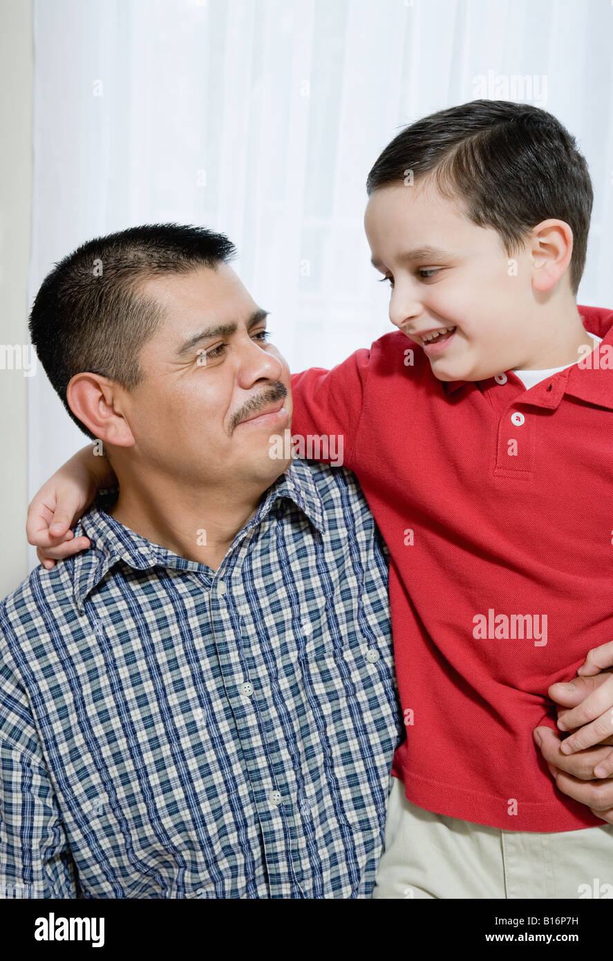 Hispanic father and son hugging Stock Photo - Alamy